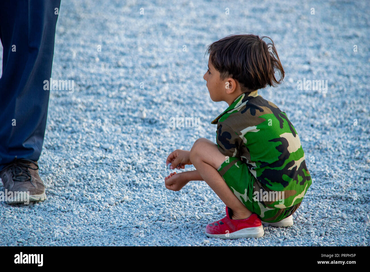 A boy squatting Stock Photo - Alamy