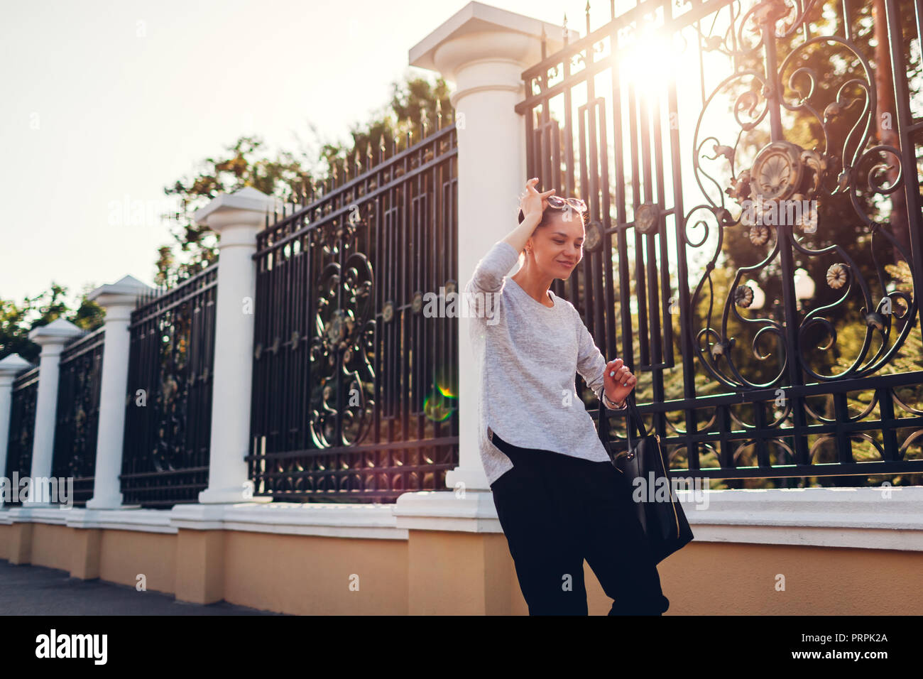 Happy young woman having fun in summer park. Girl imitates wavy walk ...