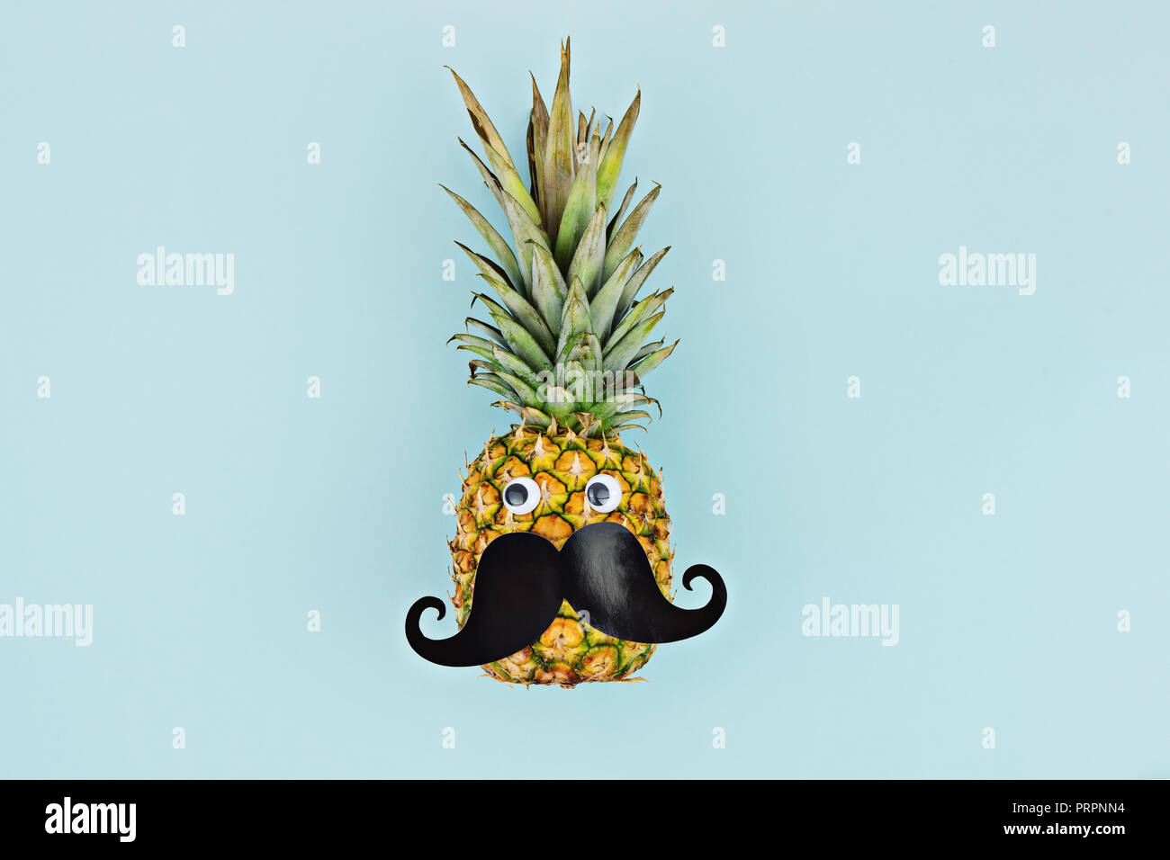 Funny face ripe fruit pineapple with mustache on blue background ...