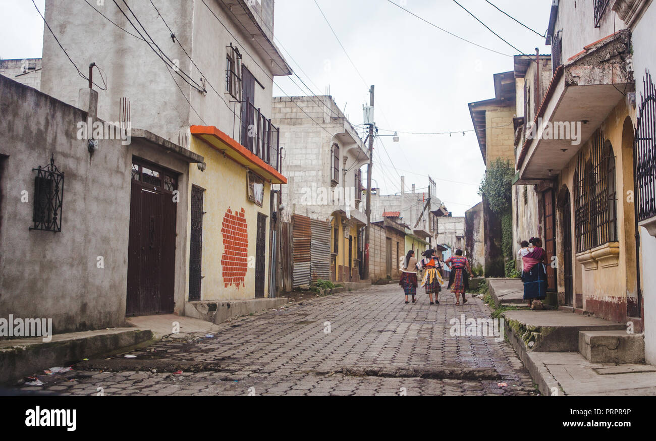 Local Mayan women in traditional dress walk down a typical street in ...
