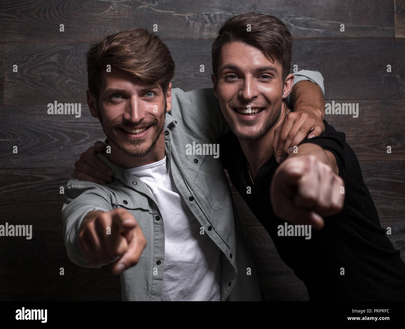 two friends point their finger at the camera Stock Photo - Alamy