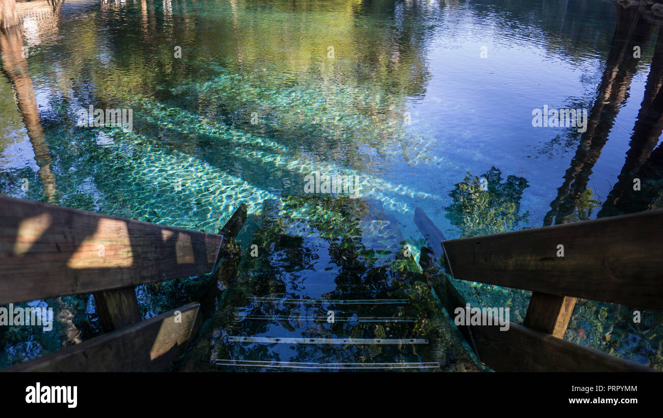 Wooden staircase steps going down to the crystal clear turquoise water ...