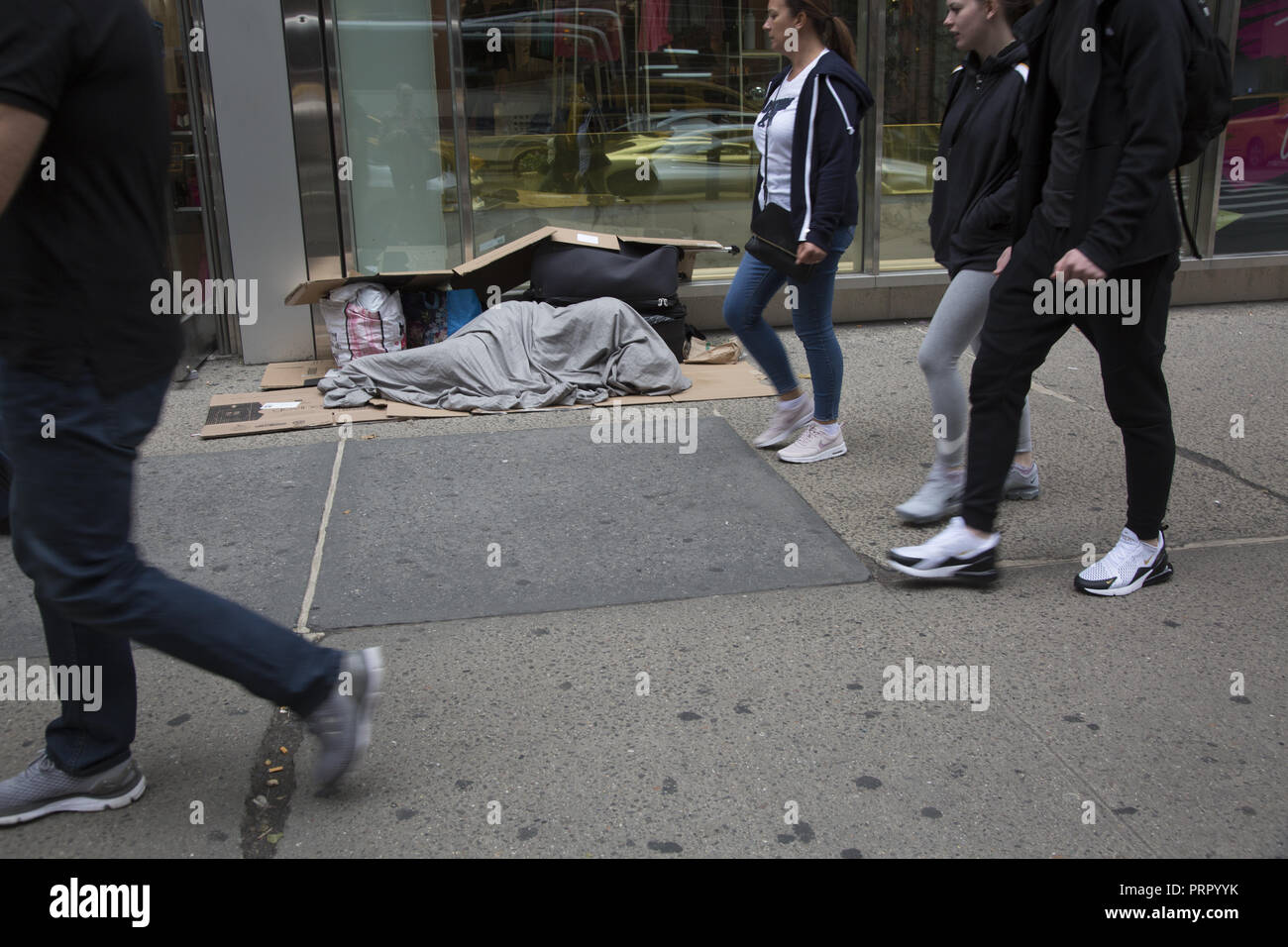 Sleeping homeless man on a sidewalk in midtown Manhattan as ...