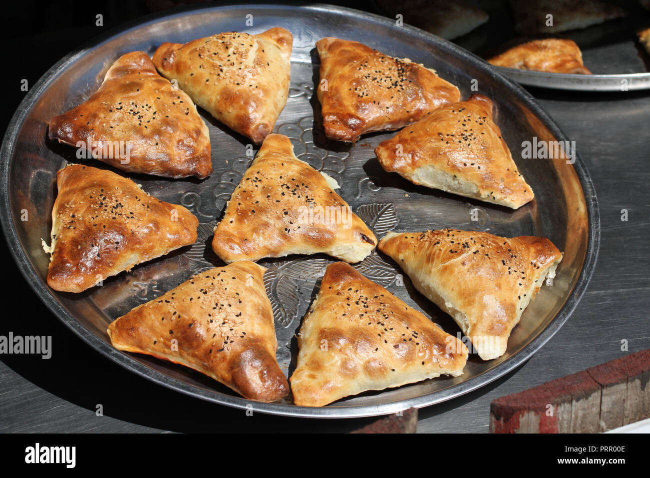 Traditional Uzbek patties (samsa) with chicken meat, lying on a large ...