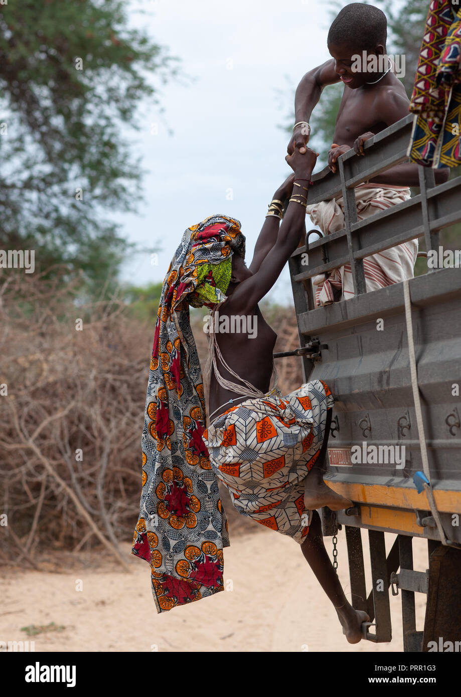 Mucubal tribe people jumping on the back of a truck, Namibe Province ...