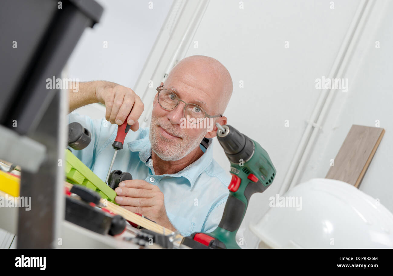 a mature man using screwdriver at home Stock Photo - Alamy