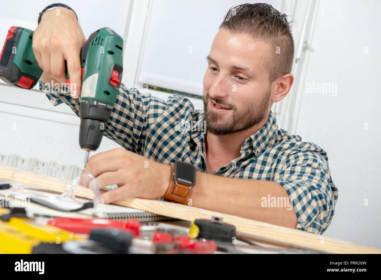 a young man DIY using electric drill Stock Photo - Alamy