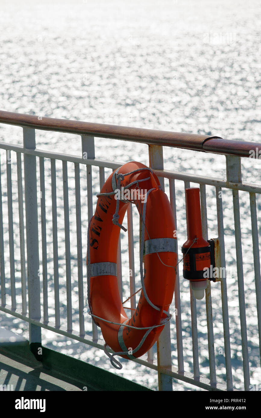 A life ring or lifebuoy attached to railings of a ship, ready to be ...