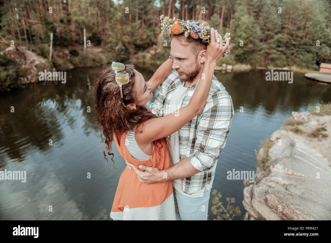 Funny curly girlfriend putting her beautiful floral chaplet on her ...