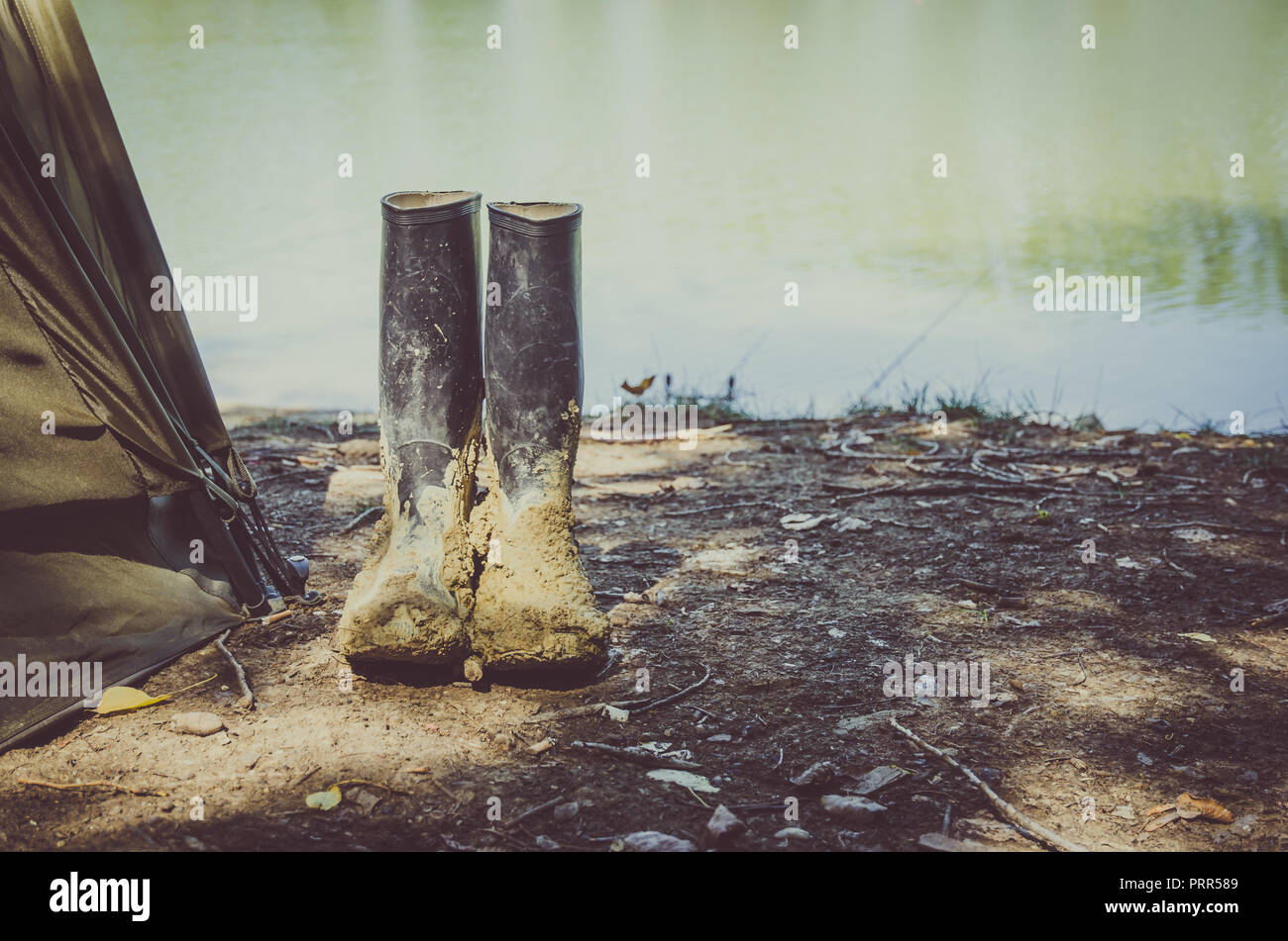 dirty boots standing next to the fishing tent by the river Stock Photo ...