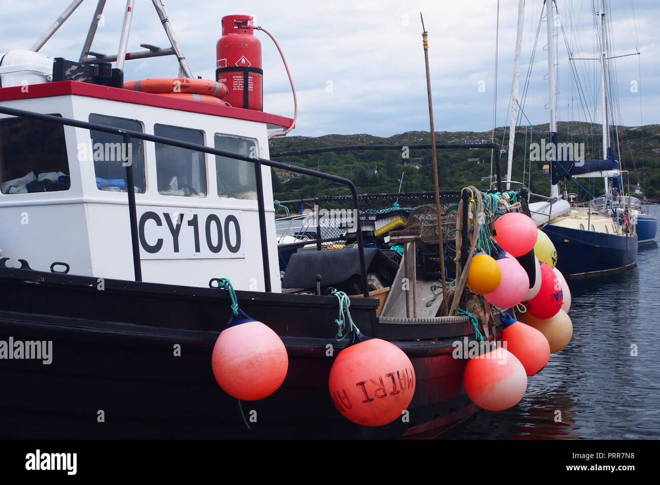 Image of the side of a small fishing boat moored in the harbour showing ...
