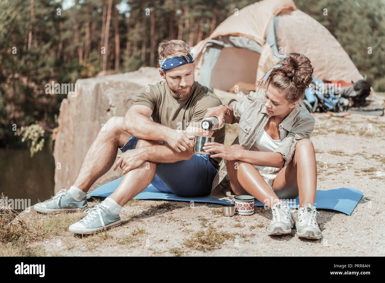 Caring girlfriend pouring some hot tea while having breakfast after ...