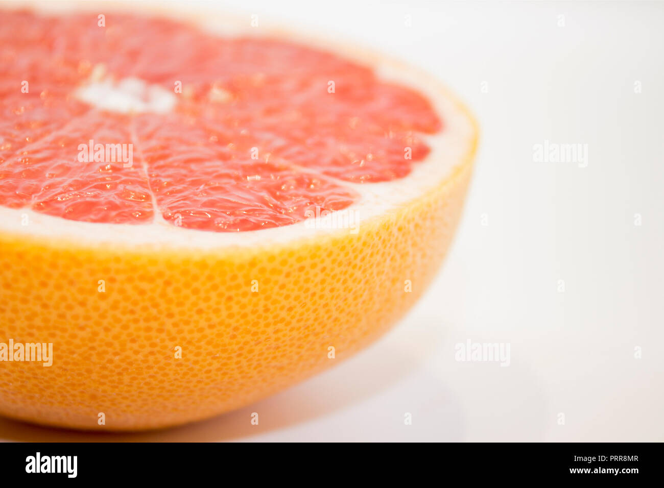Juicy grapefruit close up view on white background Stock Photo - Alamy