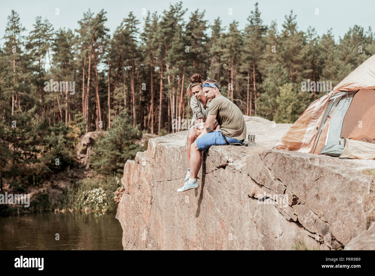 Couple sitting on edge cliff hi-res stock photography and images - Alamy