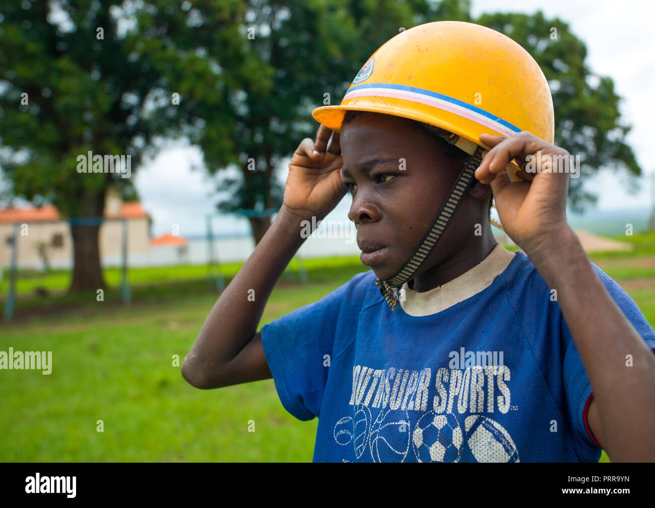 Angolan boy wearing a yellow safety helmet, Malanje Province, Calandula ...