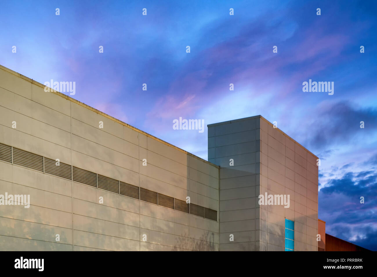 night view exterior of shopping mall centre over blue clouds in uk ...