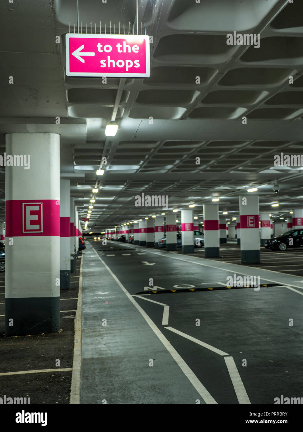 to the shops pink directional sign on brick column in shopping centre ...