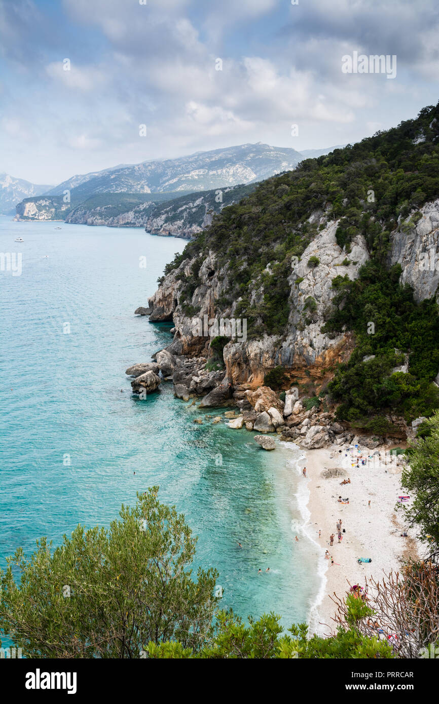 Cala Gonone beach in Sardinia with unrecognizable people on an overcast ...
