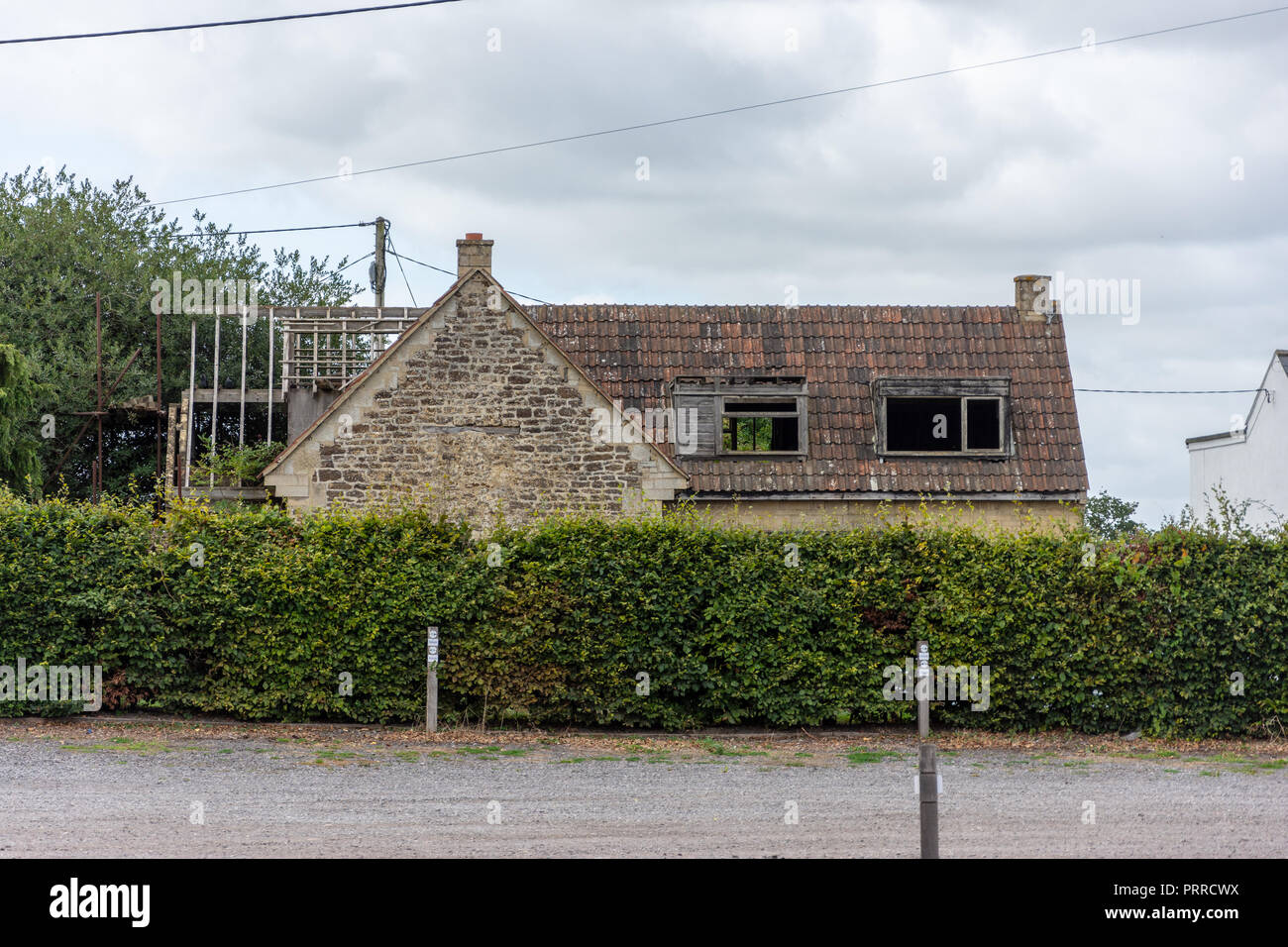 Neglected abandoned derelict house with windows and part of the roof ...