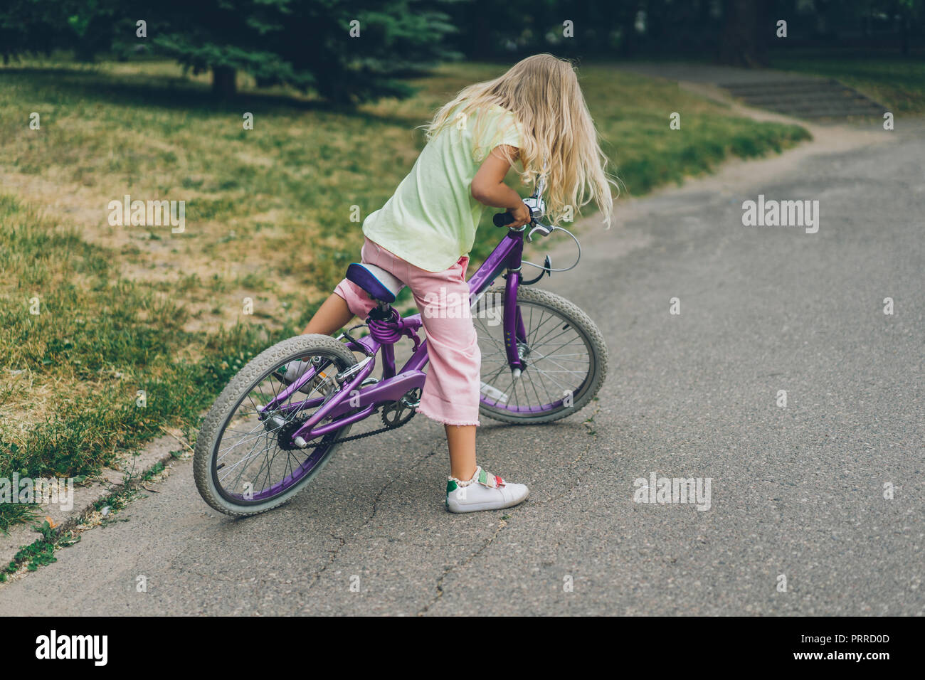 side view of cute kid with bicycle on street Stock Photo - Alamy