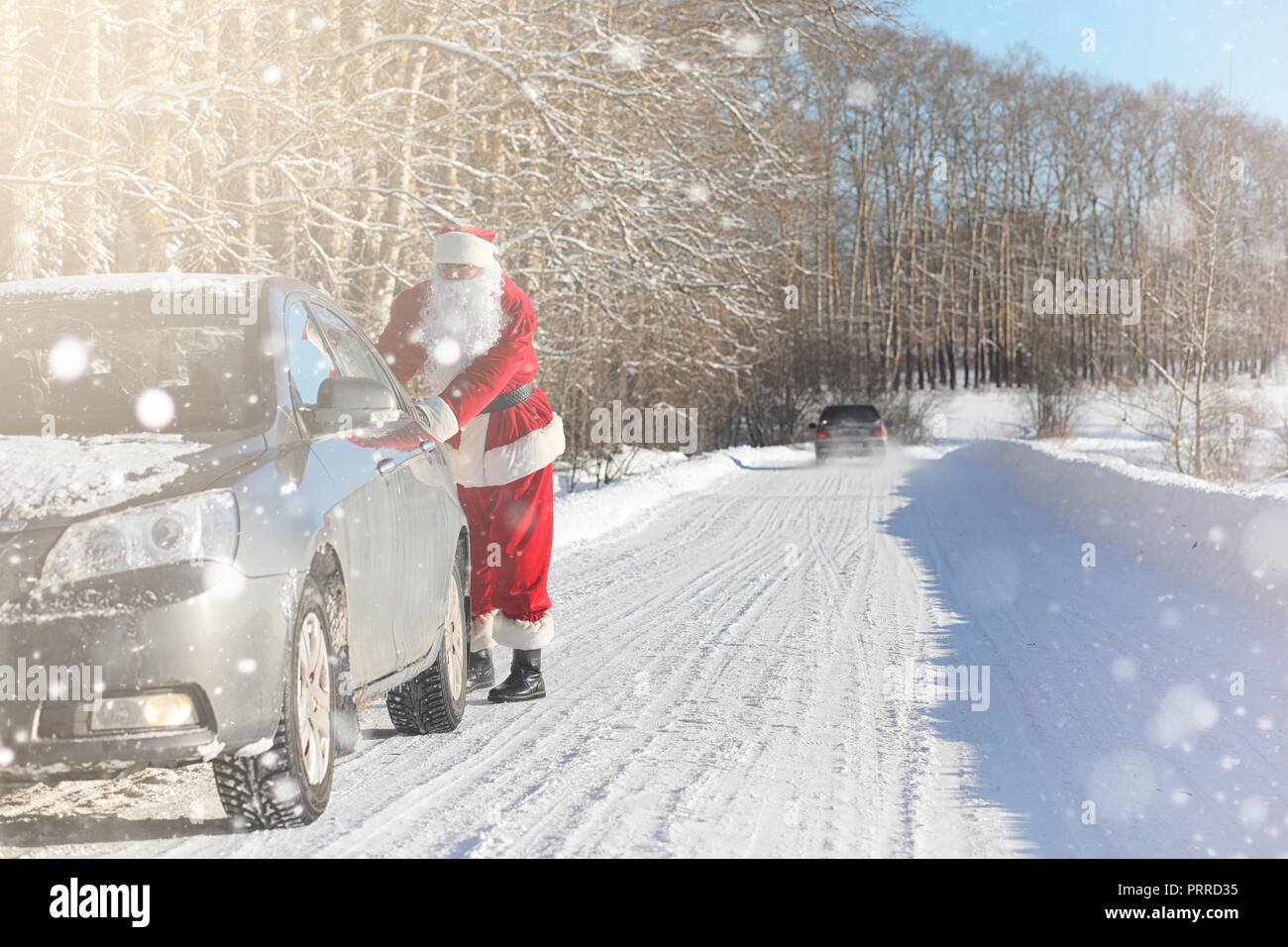 Santa Claus comes with gifts from the outdoor. Santa in a red su Stock ...