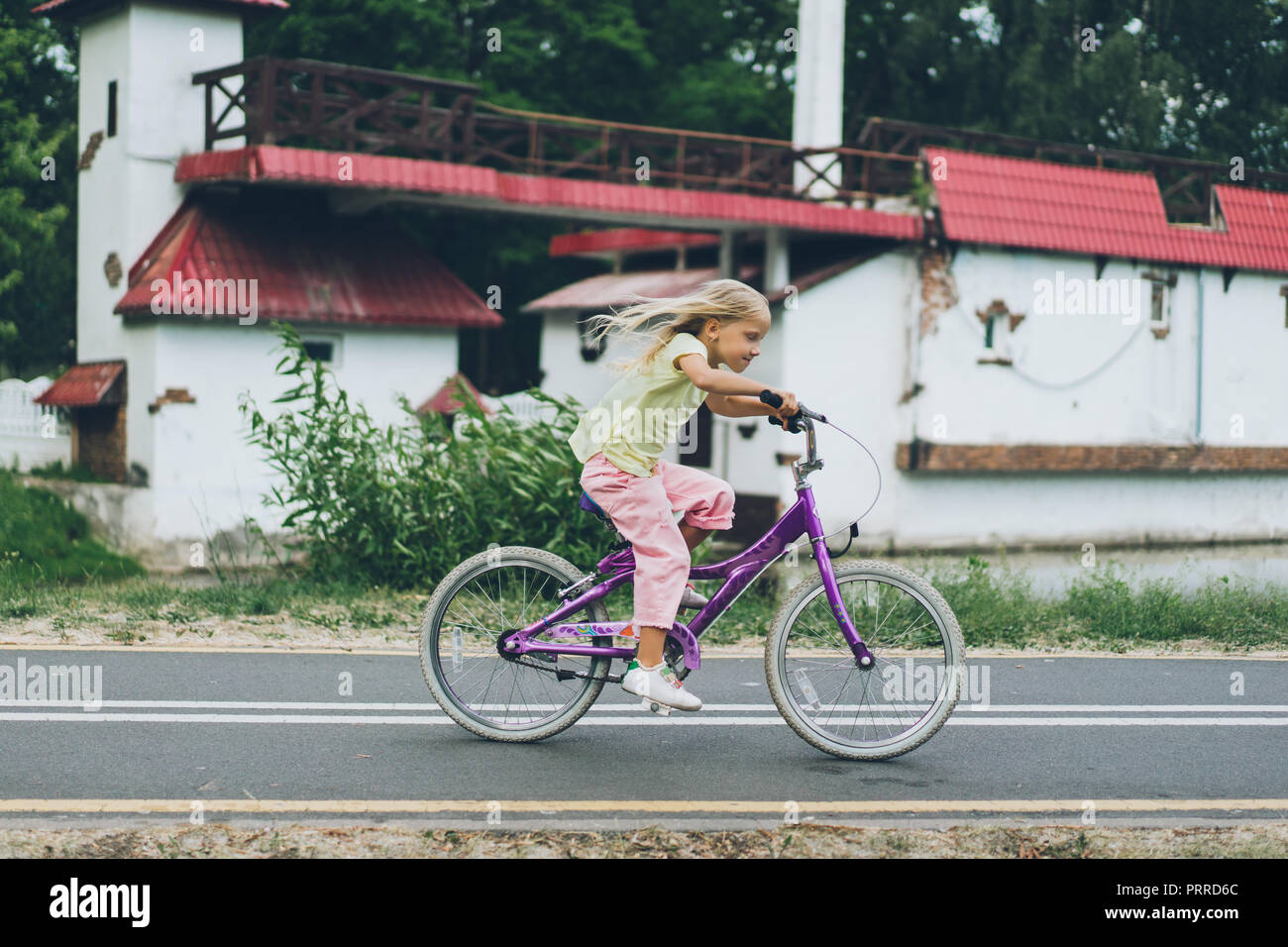 side view of cute little child riding bicycle on road Stock Photo - Alamy