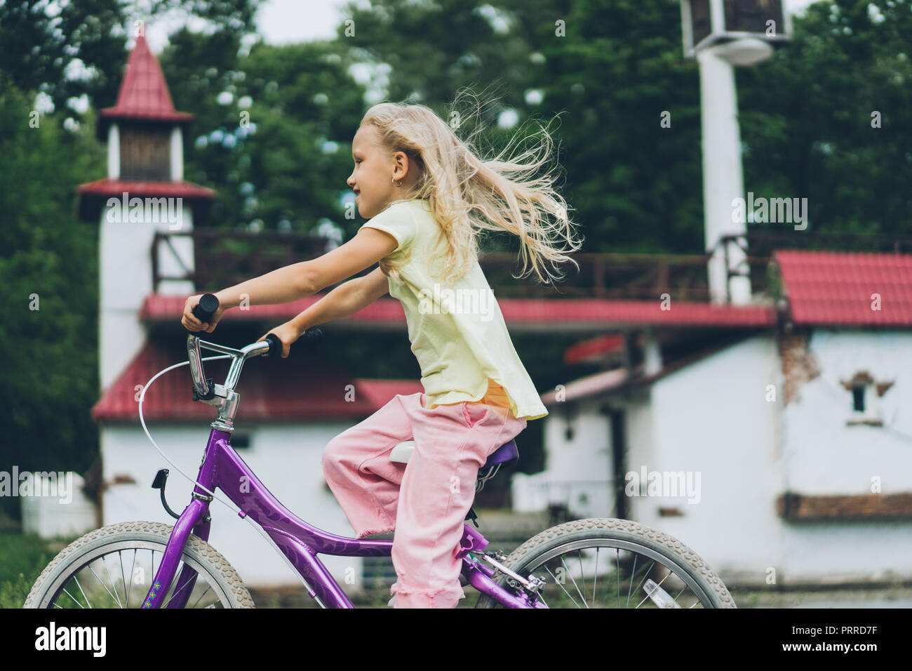 side view of cute smiling child riding bicycle Stock Photo - Alamy