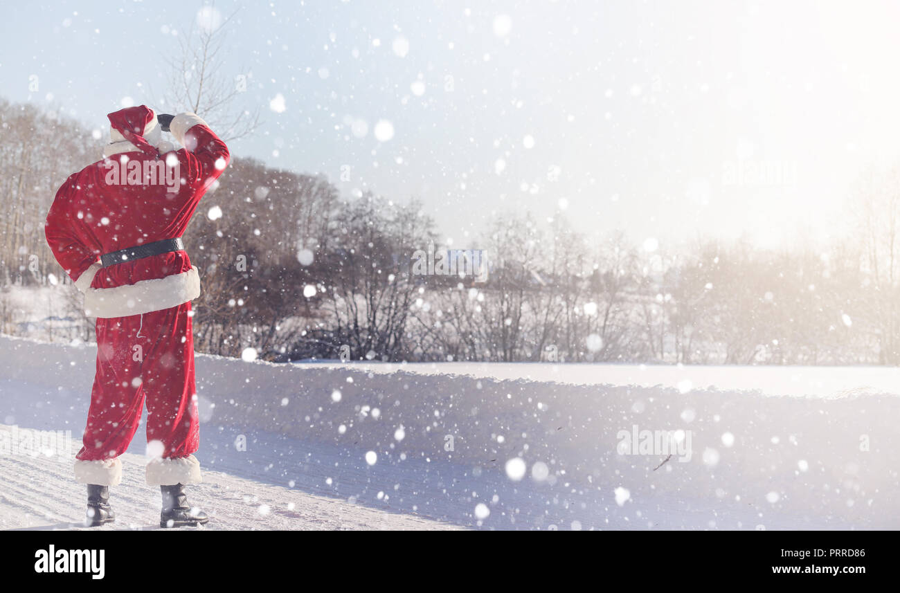 Santa Claus comes with gifts from the outdoor. Santa in a red su Stock ...