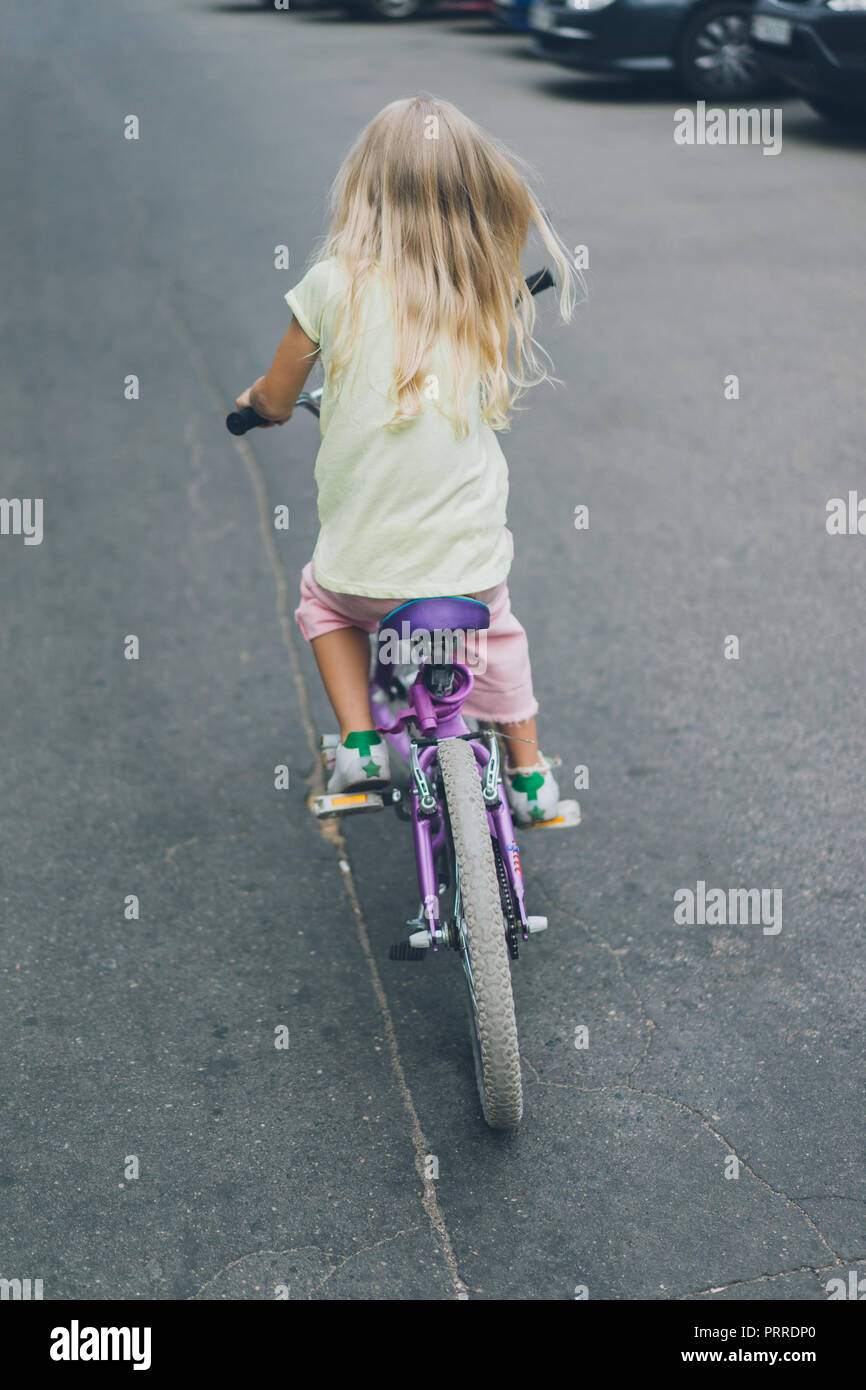 back view of cute kid riding bicycle on street Stock Photo - Alamy