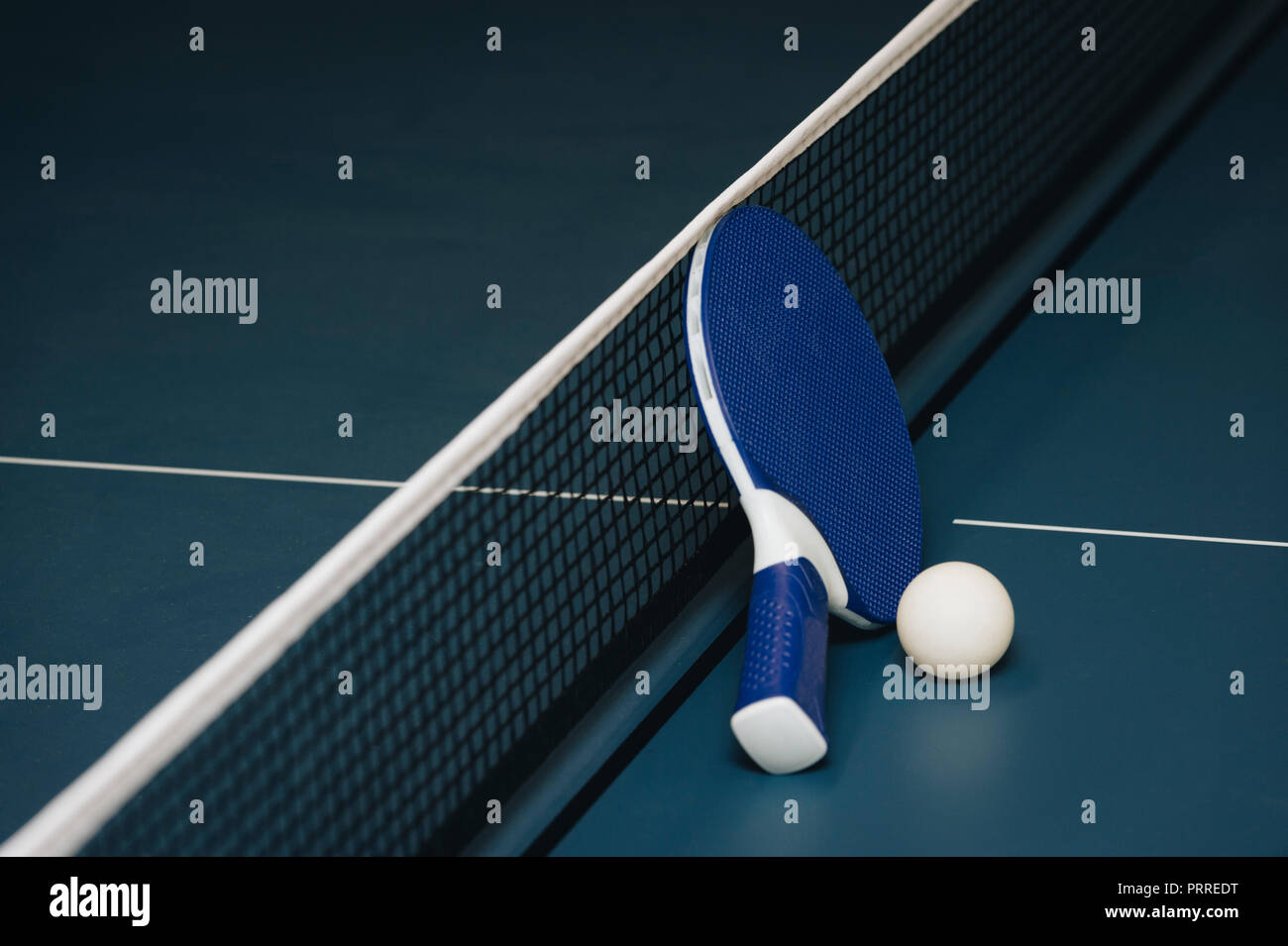 Table tennis rackets and ball and net on a blue pingpong table Stock ...