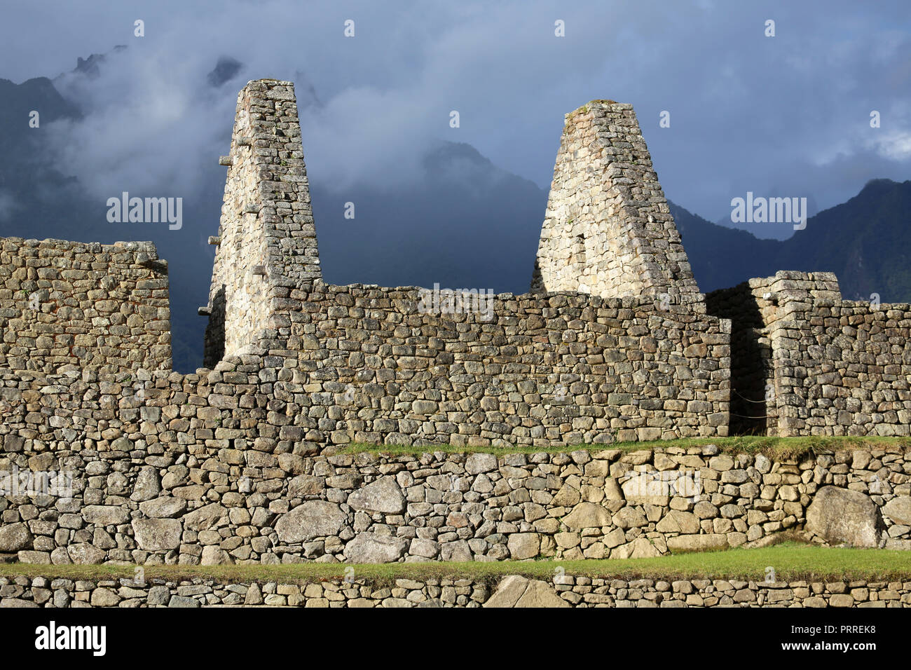 Inca stone ruins in light with dark mountains in background Stock Photo ...
