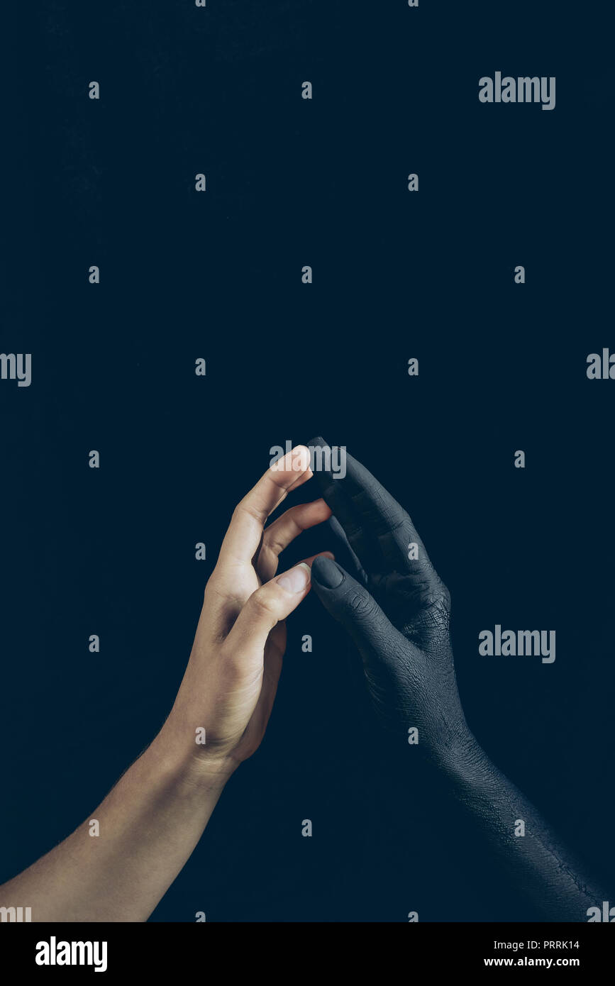 cropped view of woman touching with black demon hand isolated on black ...