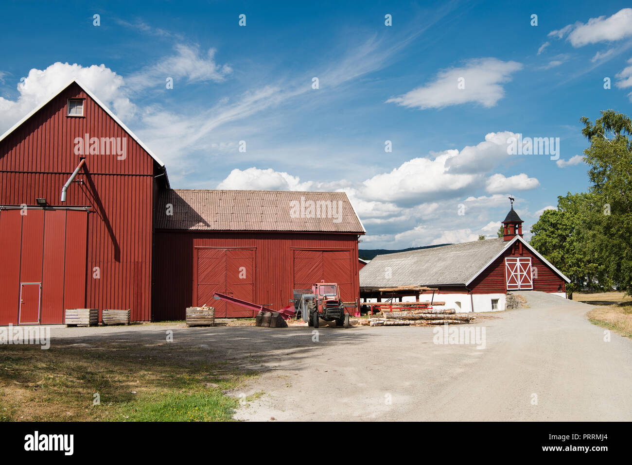 backyard of red farm buildings under blue sky, Hamar, Hedmark, Norway ...
