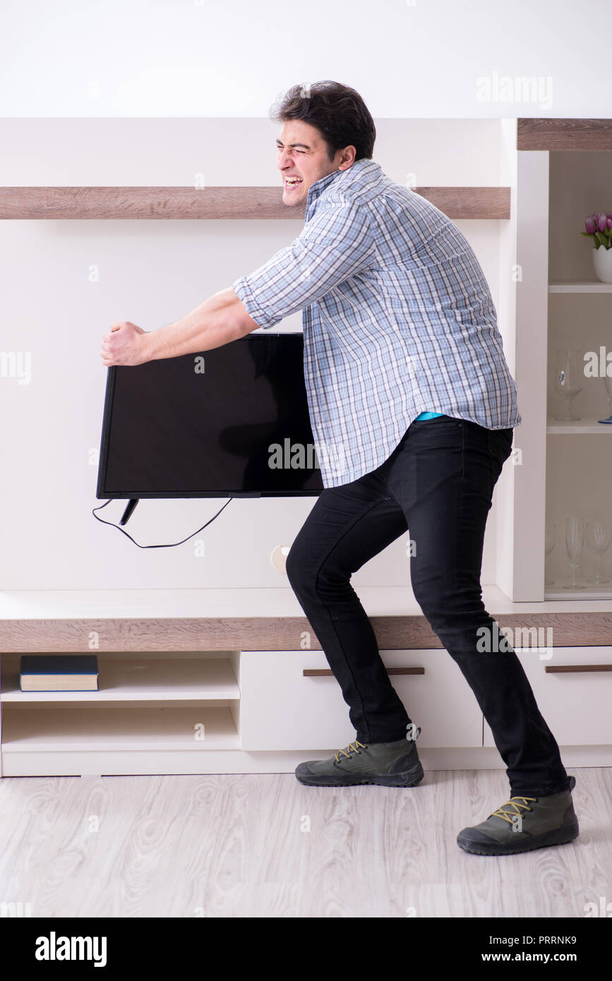 Man trying to fix broken tv Stock Photo - Alamy