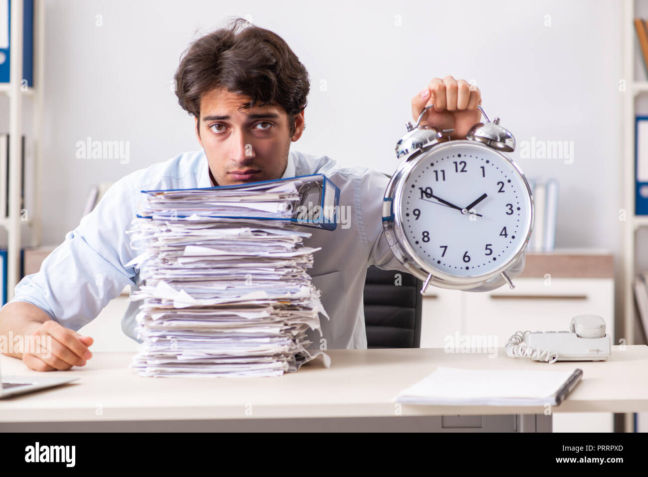 Overloaded busy employee with too much work and paperwork Stock Photo ...