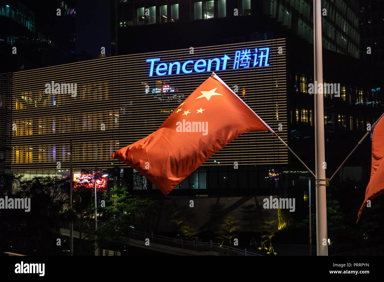 Chinese flag billowing in front of Tencent headquarters building in ...