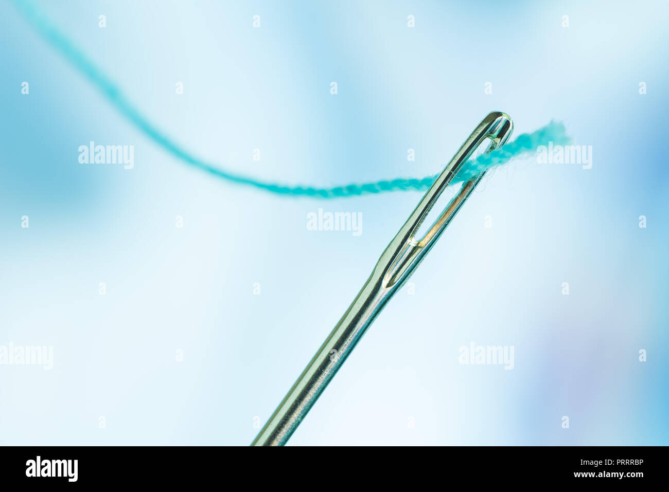 Blue thread and silver needle isolated on abstract background Stock ...