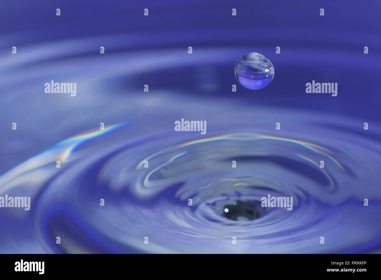 Colorful water droplet bouncing on water Stock Photo - Alamy
