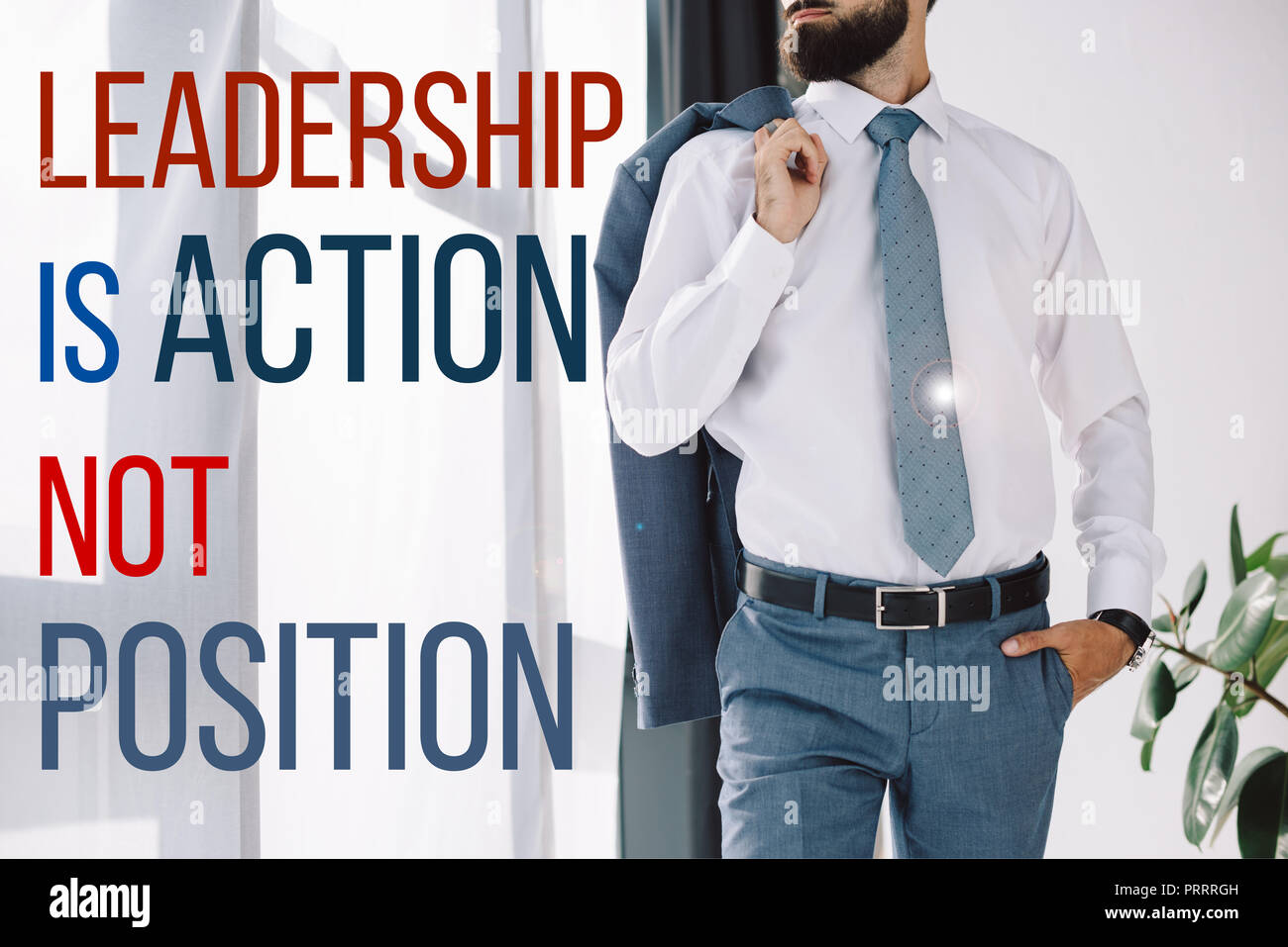 cropped view of businessman holding jacket and standing near window ...