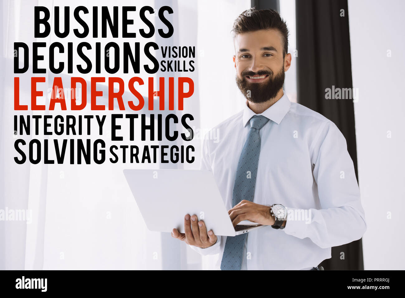 bearded smiling businessman using laptop near window with leadership ...