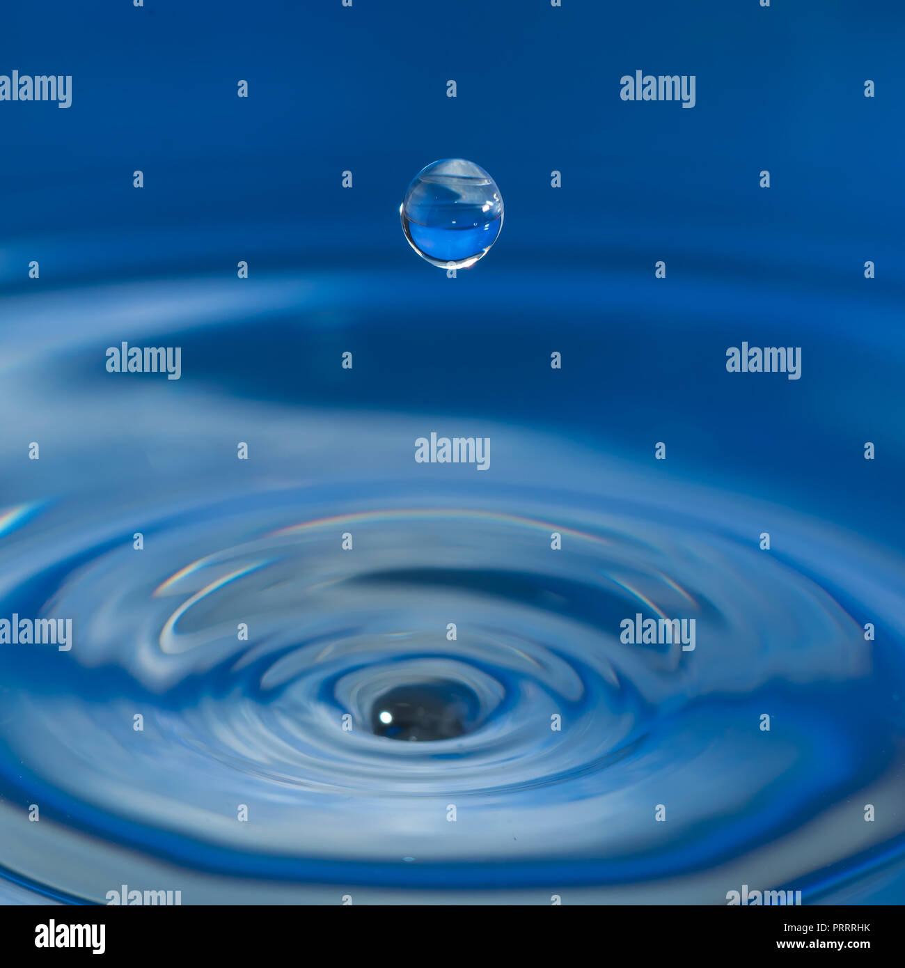 Colorful water droplet bouncing on water Stock Photo - Alamy