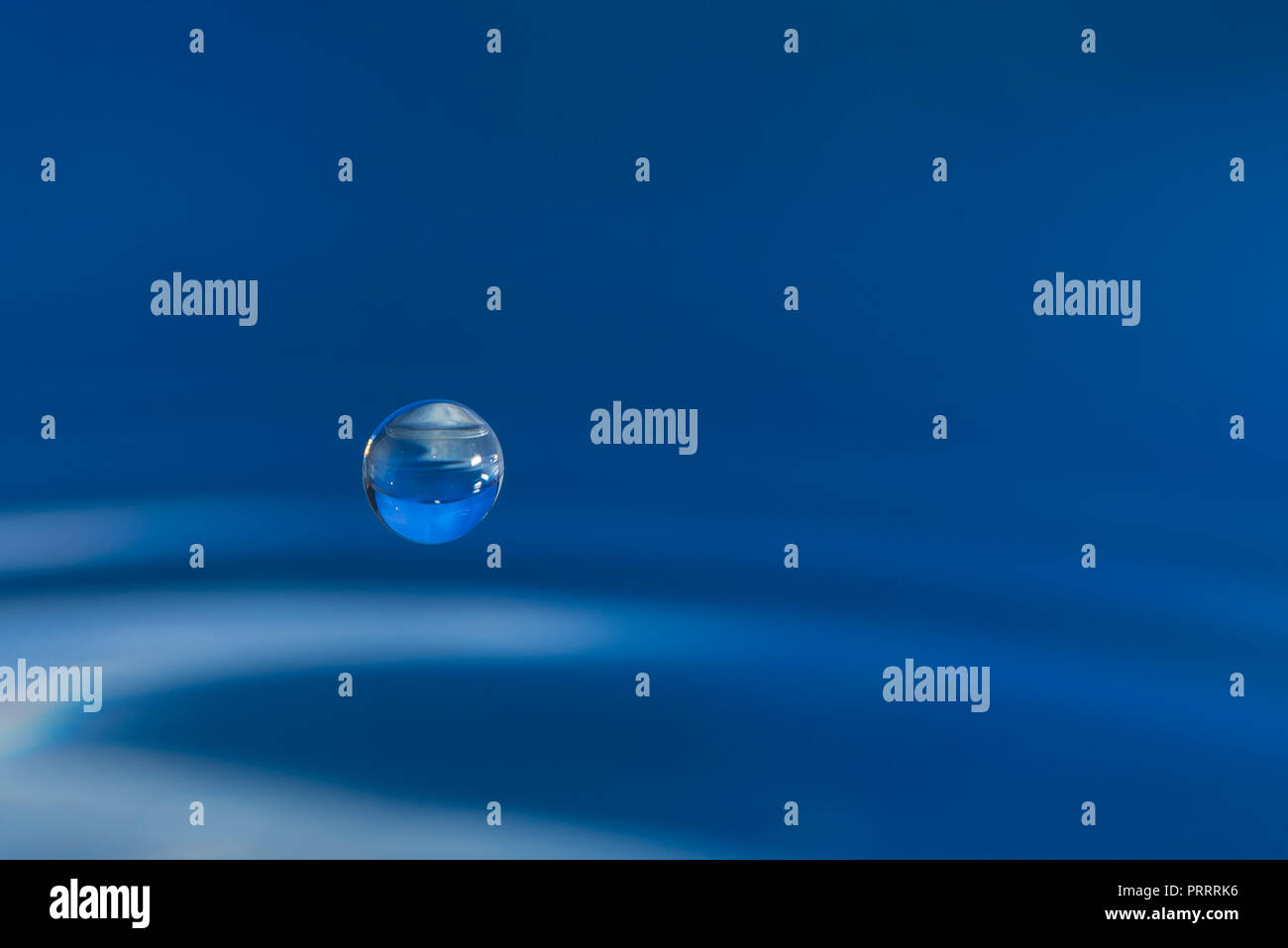 Colorful water droplet bouncing on water Stock Photo - Alamy