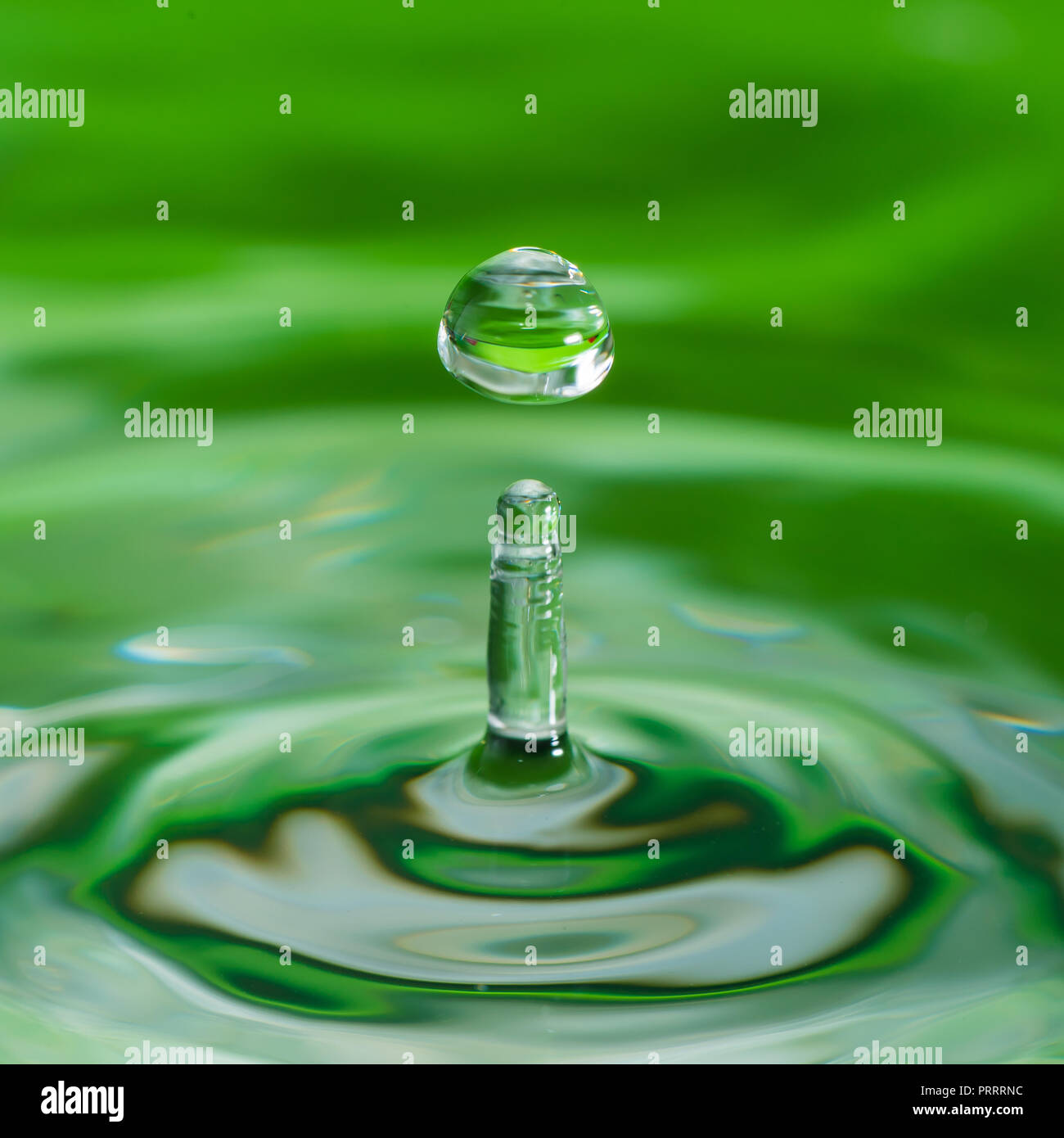 Colorful water droplet bouncing on water Stock Photo - Alamy