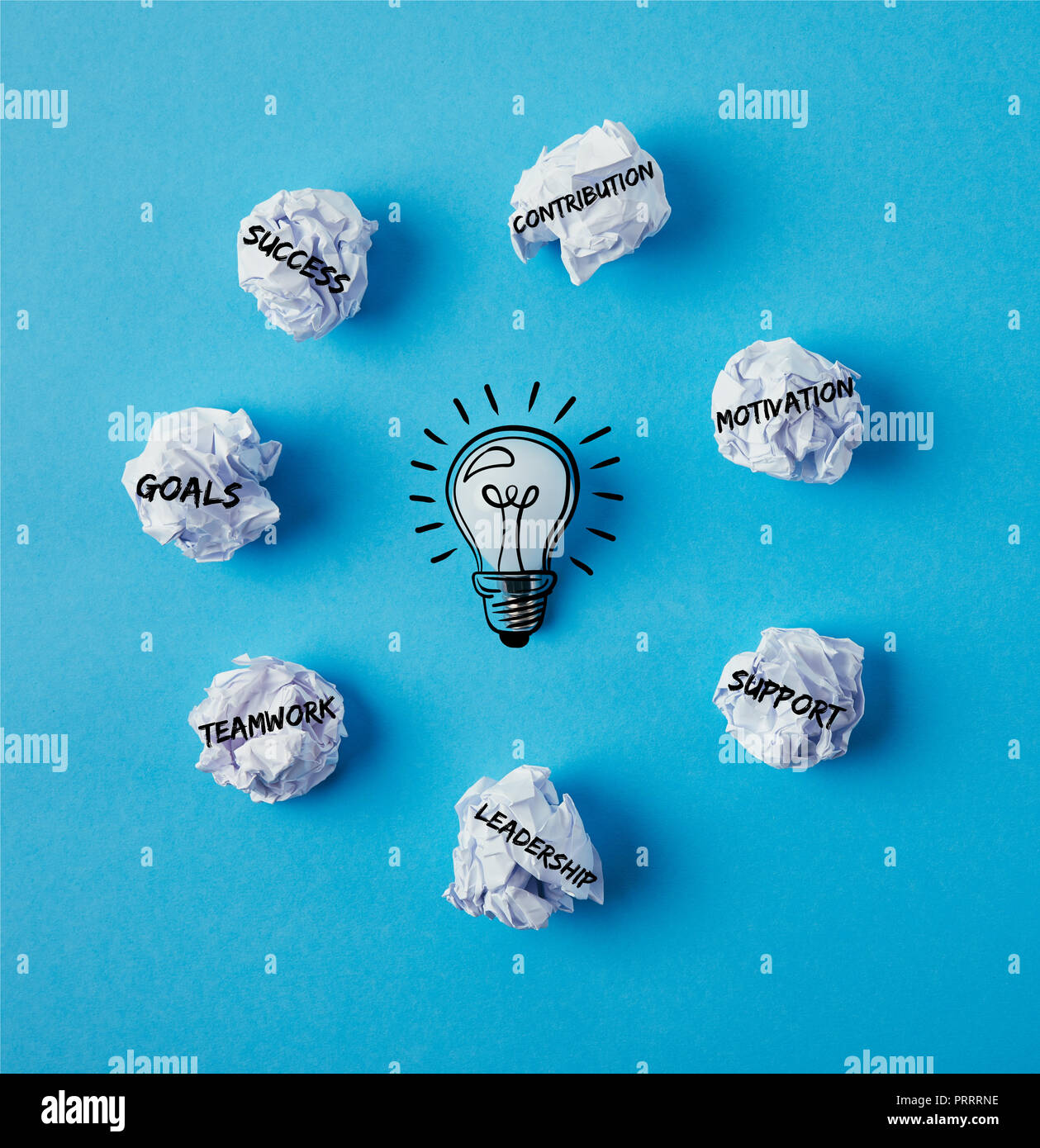 top view of light bulb surrounded with crumpled papers with business ...