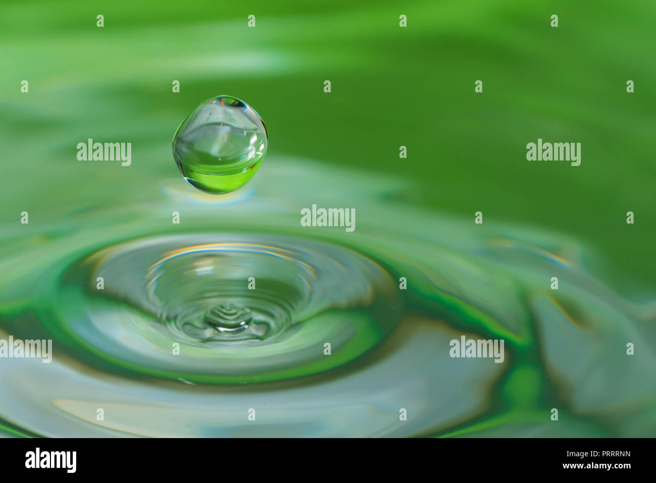 Colorful water droplet bouncing on water Stock Photo - Alamy