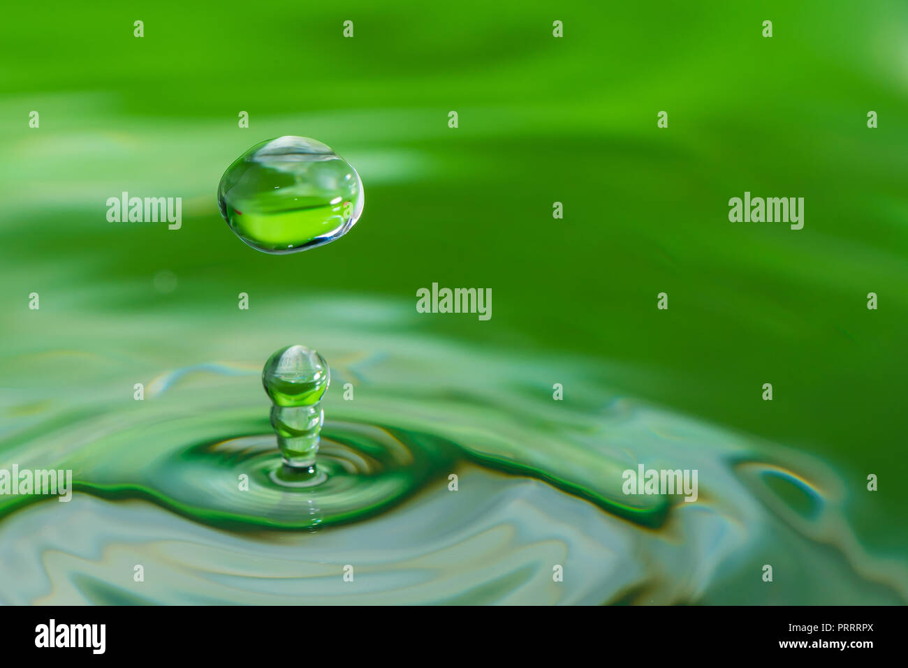 Colorful water droplet bouncing on water Stock Photo - Alamy