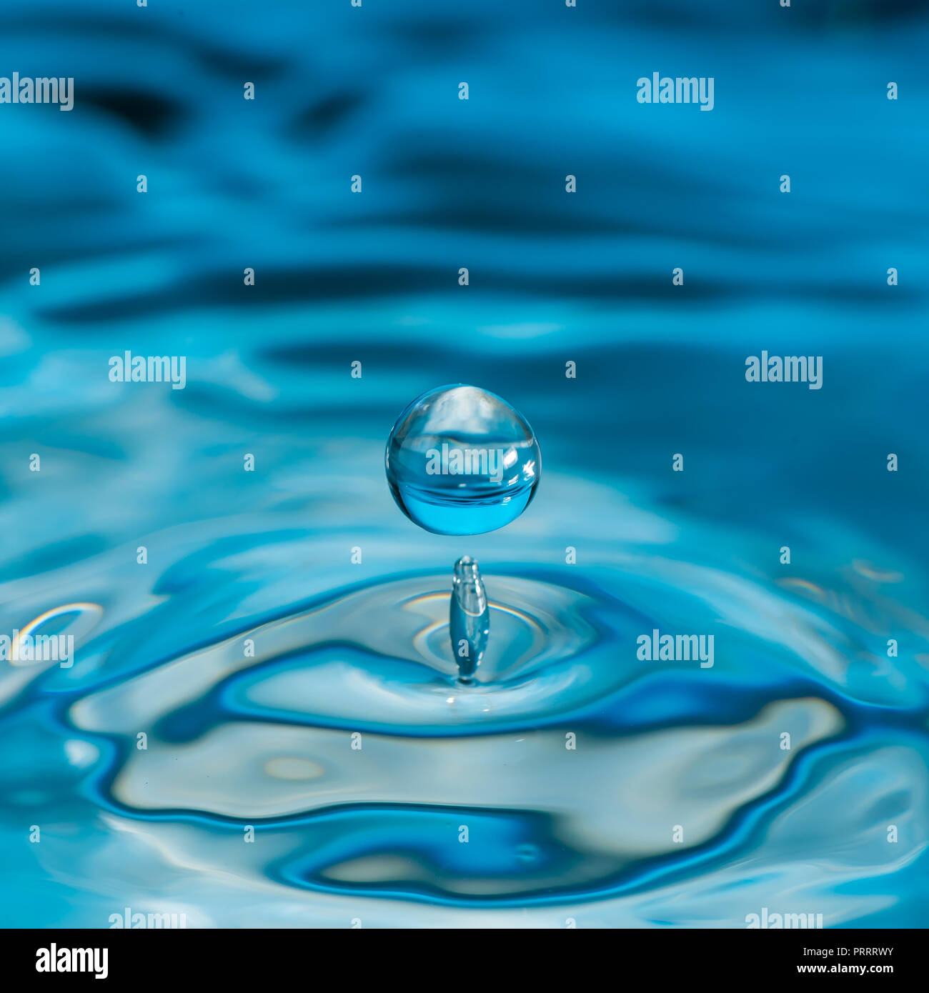 Colorful water droplet bouncing on water Stock Photo - Alamy