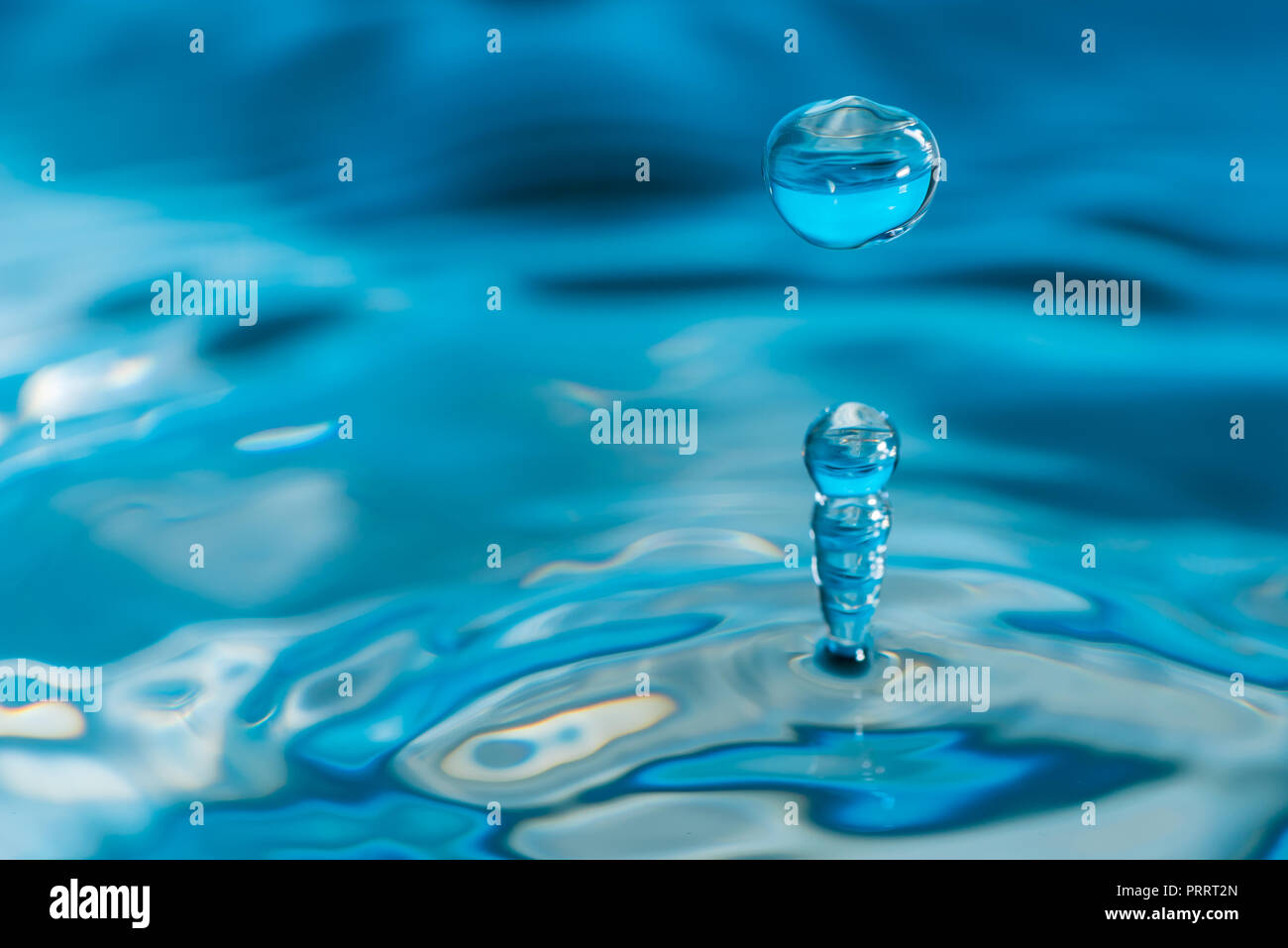 Colorful water droplet bouncing on water Stock Photo - Alamy