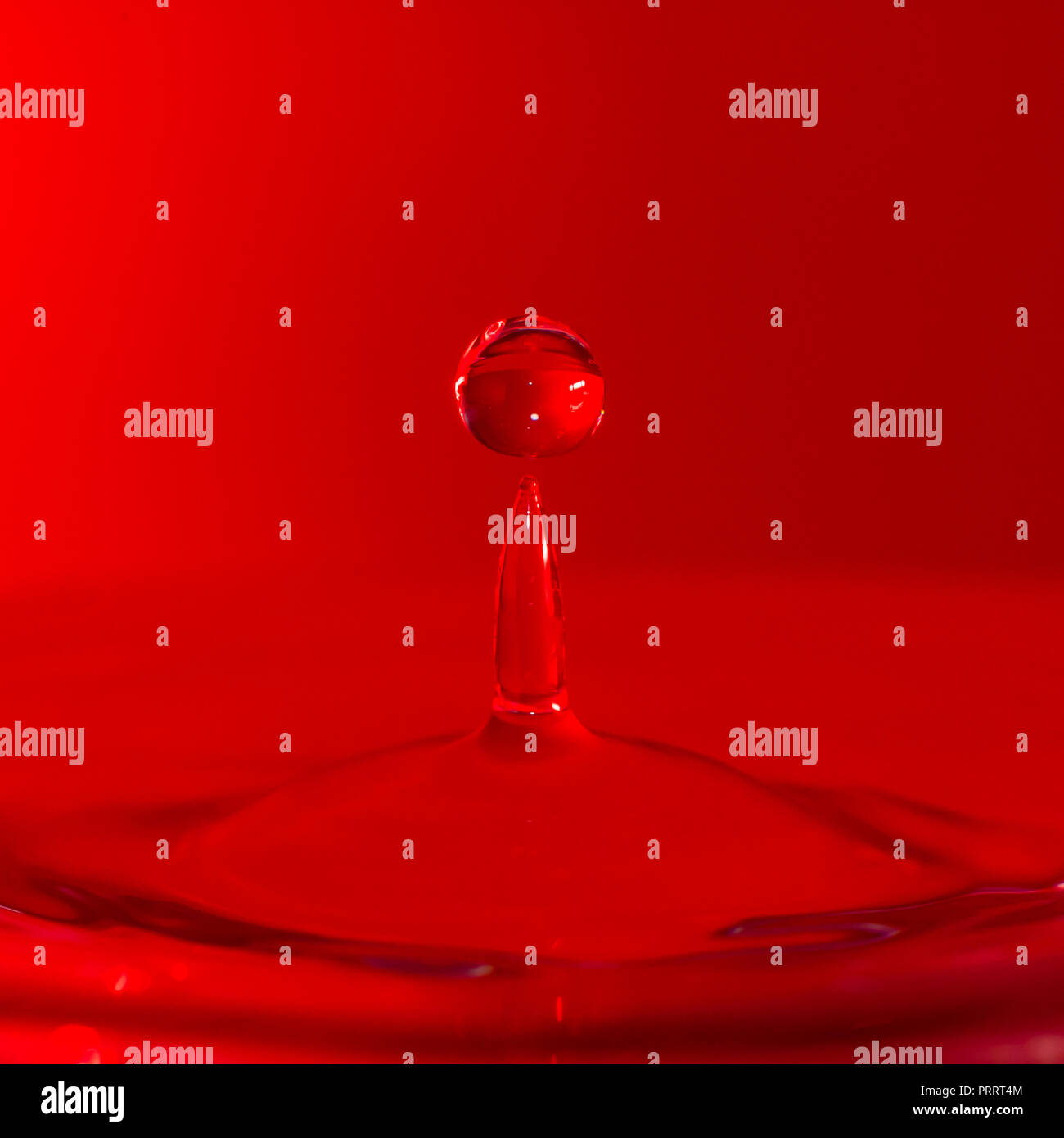 Colorful water droplet bouncing on water Stock Photo - Alamy