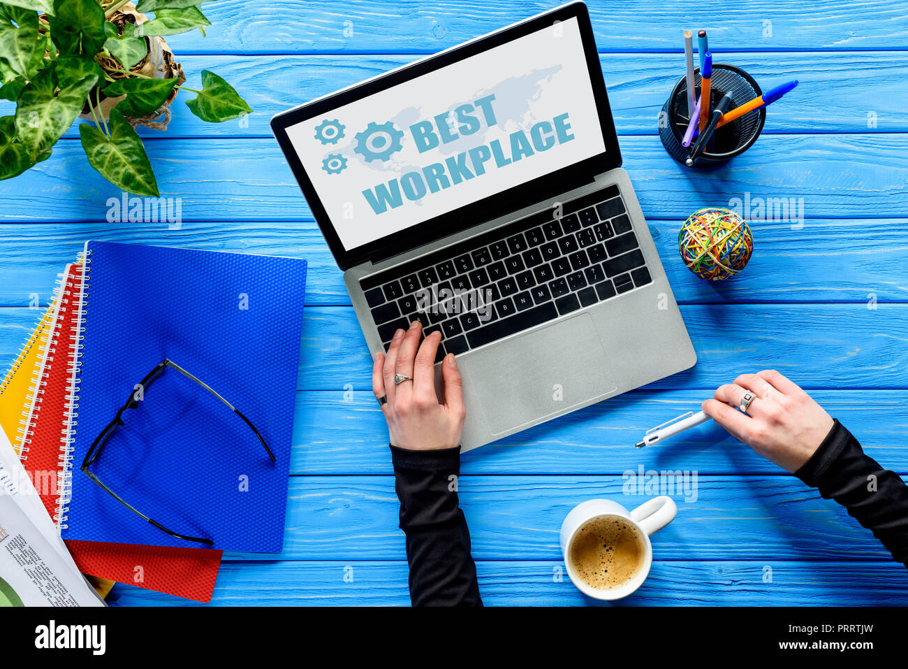 hand typing on laptop keyboard on blue wooden table with stationery and ...